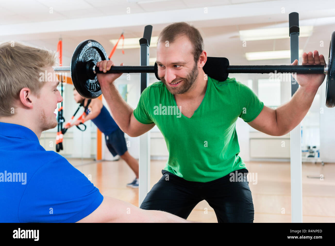 Athlete weightlifting in gym studio with his training partner Stock ...