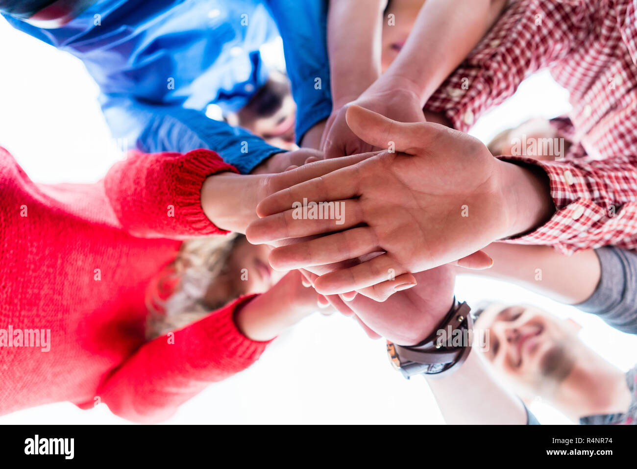 Students learning and stacking hands together Stock Photo - Alamy
