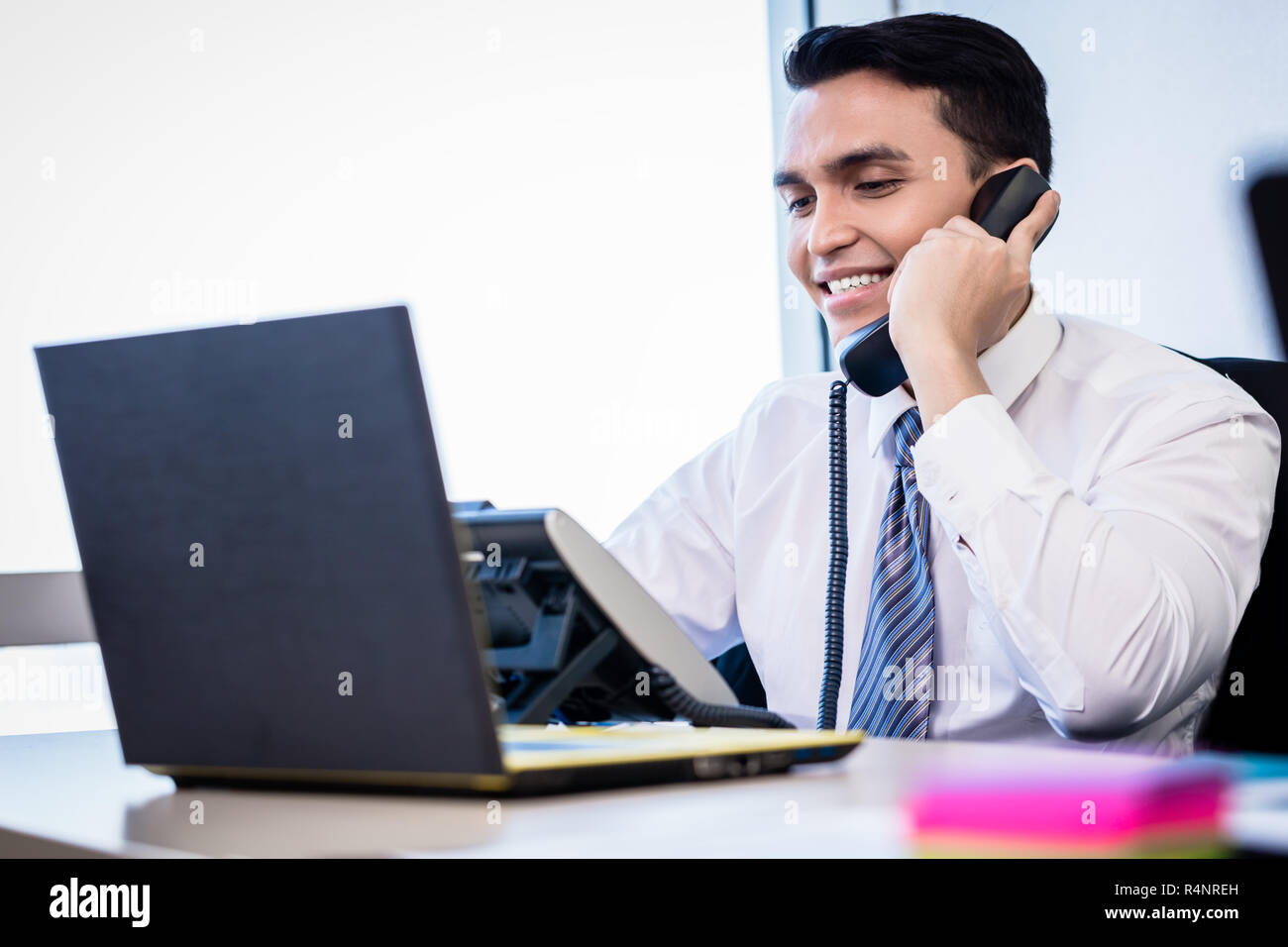 Salesman in office making phone call Stock Photo - Alamy