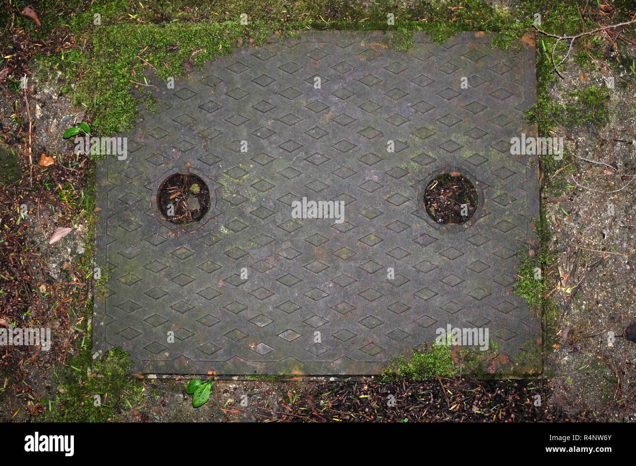 Metal drain cover in concrete path Stock Photo - Alamy