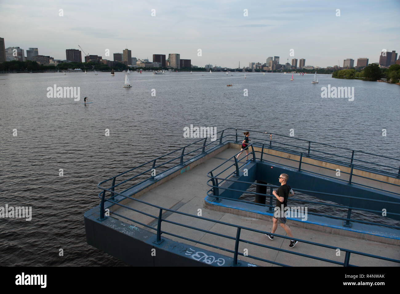 View of two runners on bridge along Charles River, Boston ...