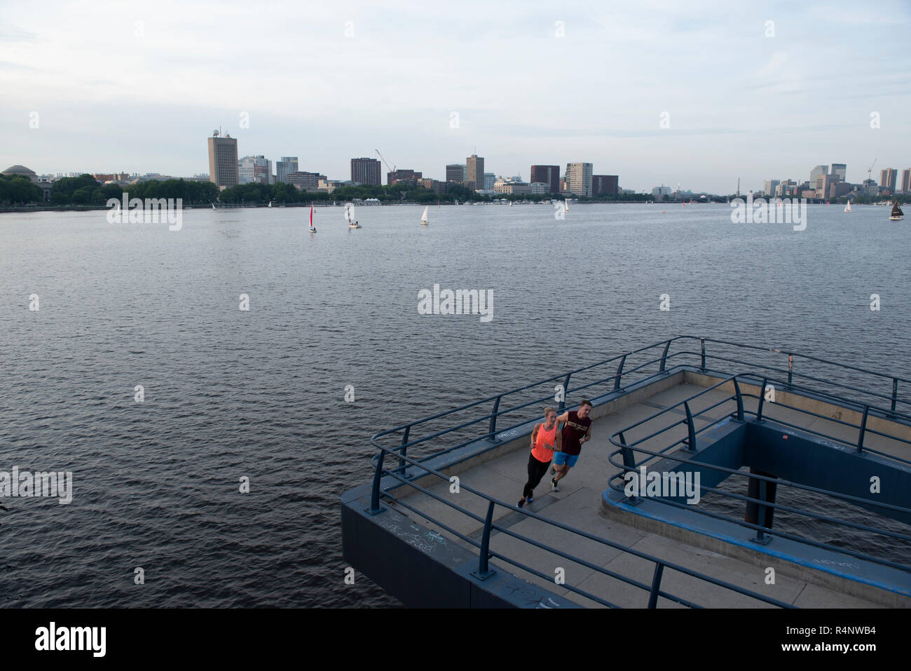 View of two runners on bridge along Charles River, Boston ...