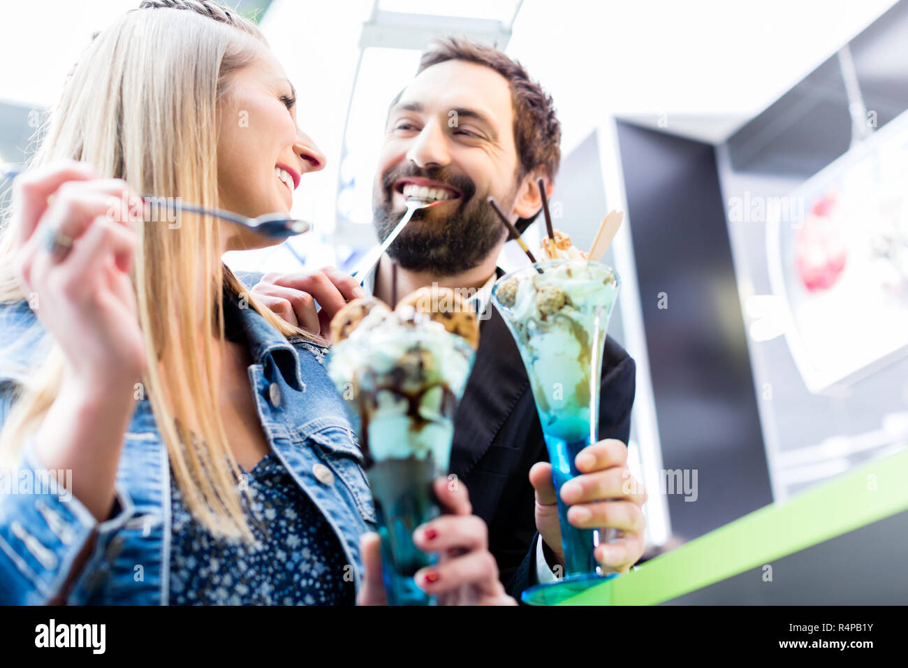 Couple enjoying an ice cream sundae in cafe Stock Photo - Alamy