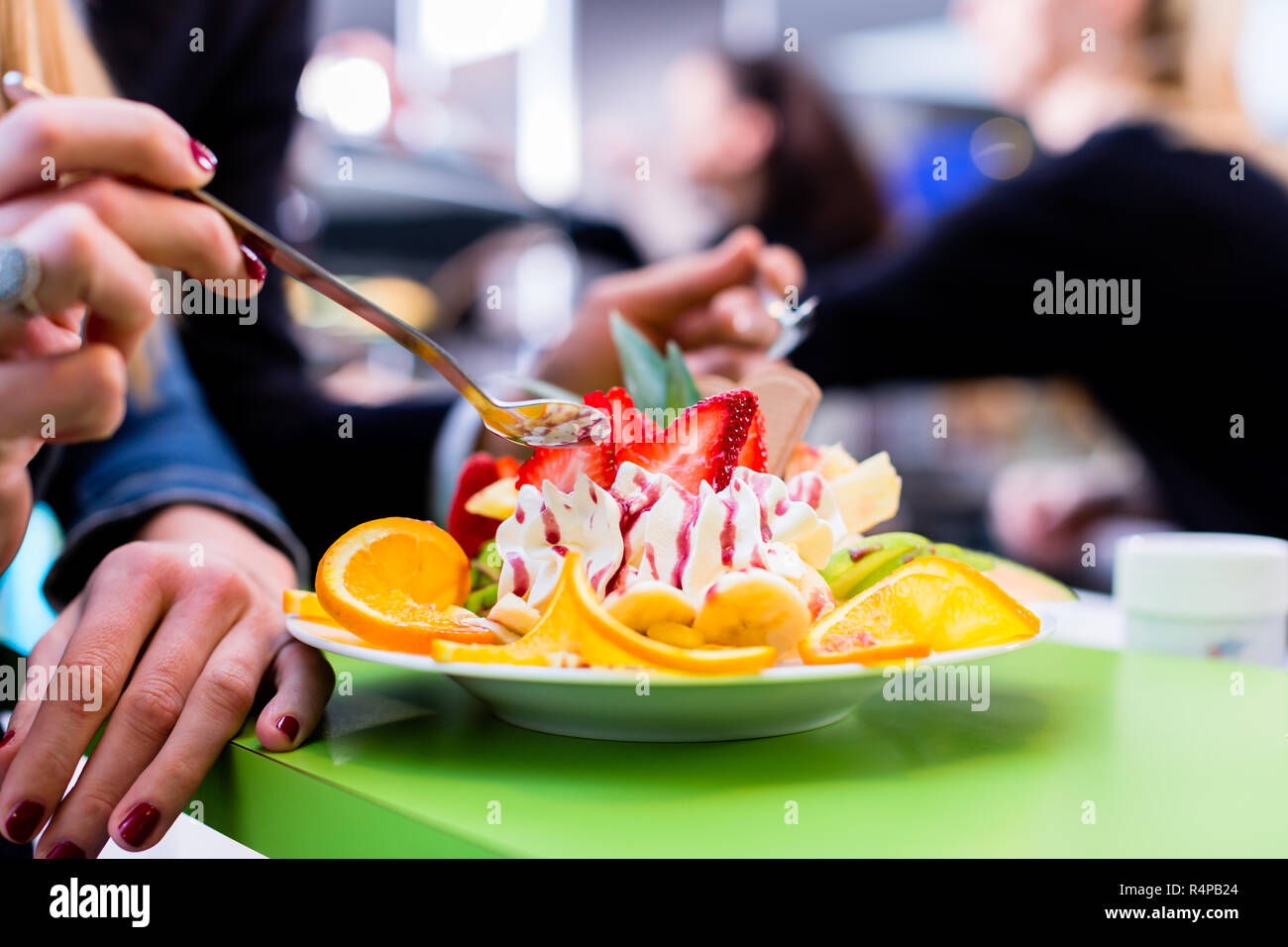 Woman eating fruit sundae in ice cream cafe Stock Photo - Alamy
