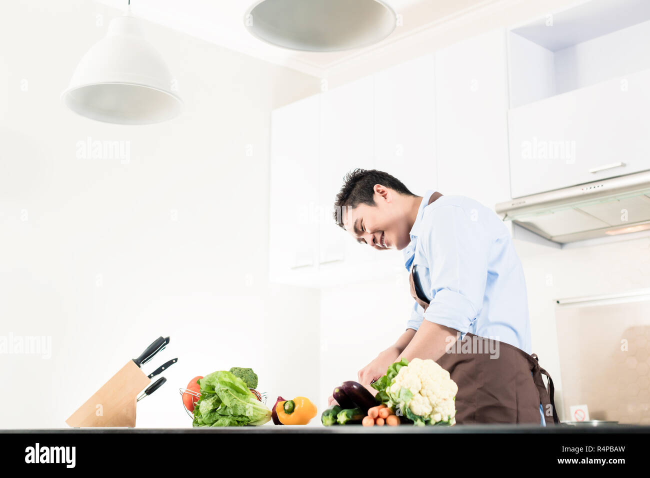 Japanese man cooking food in minimalist kitchen Stock Photo - Alamy