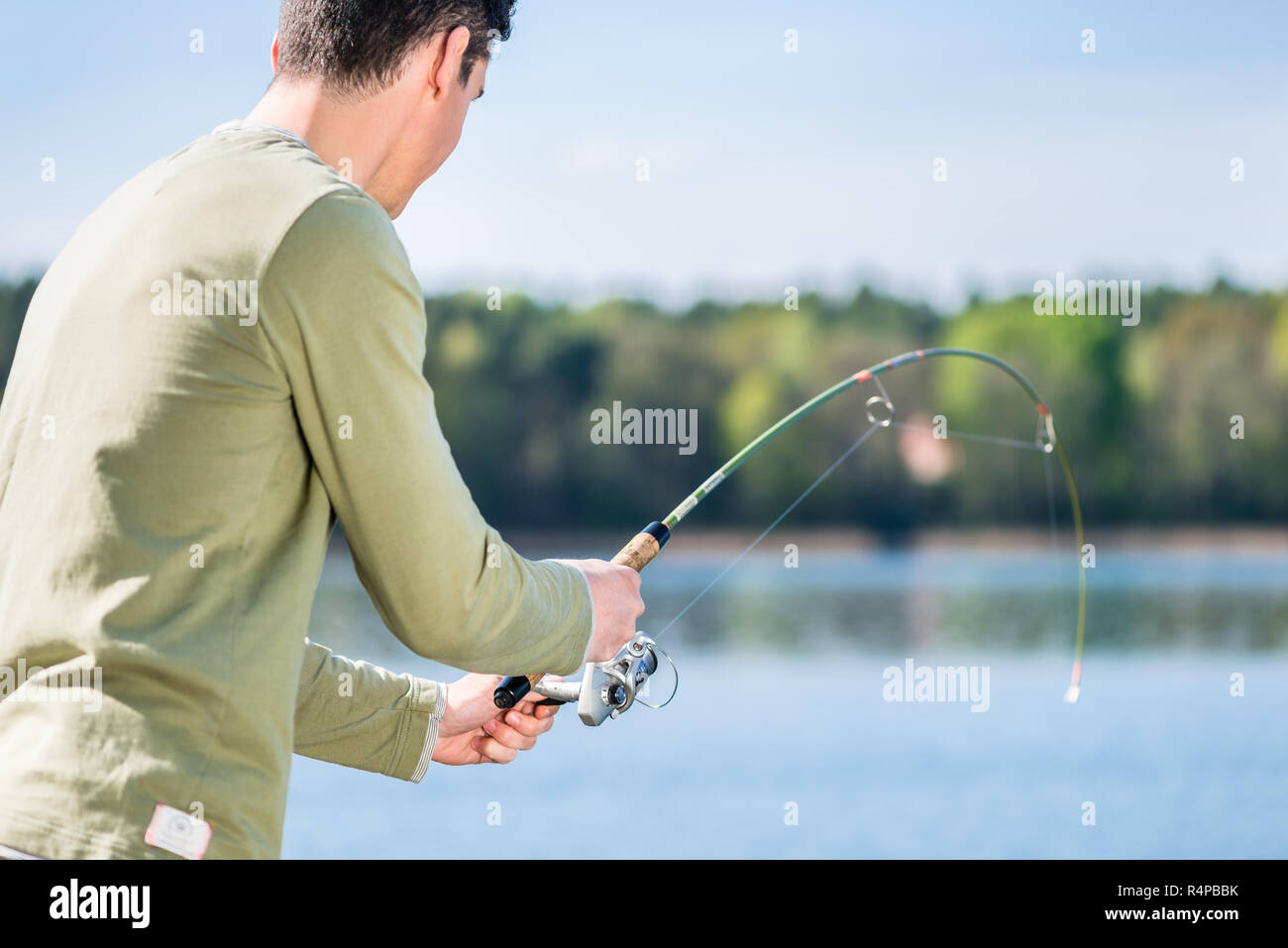 Fisherman at lake fishing for sport Stock Photo - Alamy