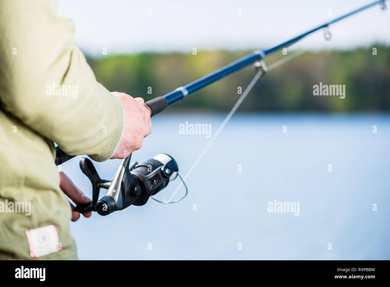 Man fishing with angle at lake Stock Photo - Alamy