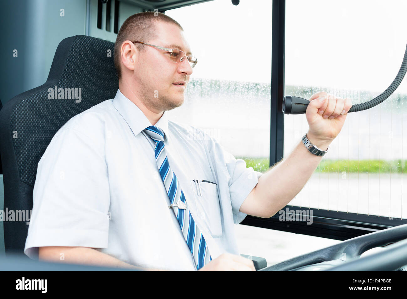 Bus driver making announcement using microphone Stock Photo - Alamy