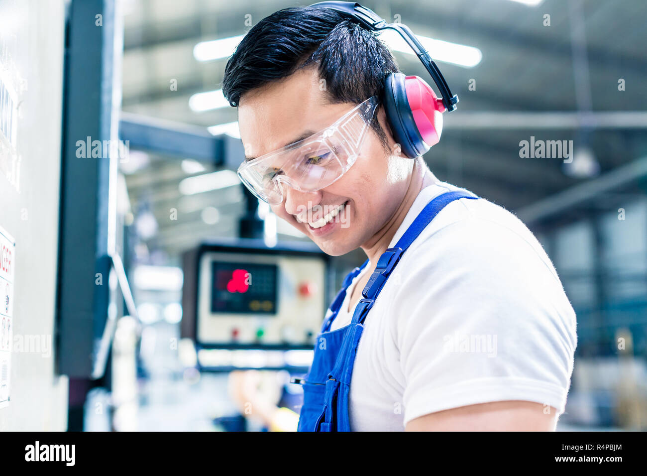 Asian machine operator in production plant Stock Photo - Alamy
