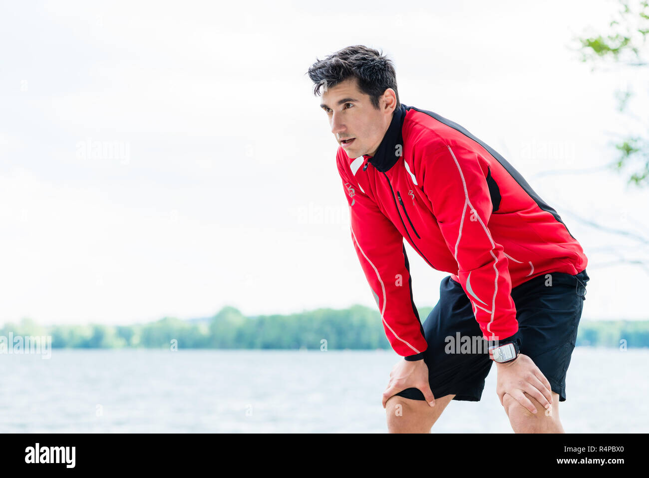 Woman and man at break from running in front of lake Stock Photo - Alamy