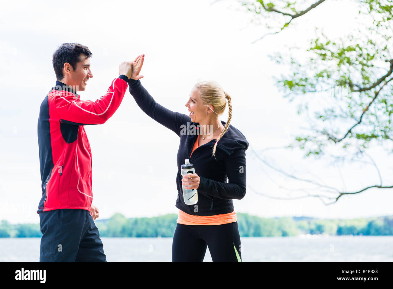 Woman and man at break from running giving each other a high five Stock ...