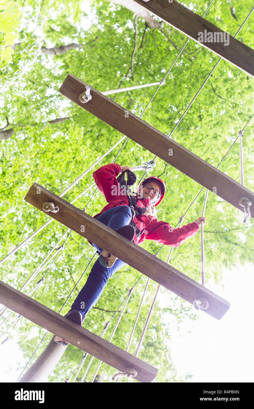 Kid walking on rope bridge in climbing course Stock Photo - Alamy