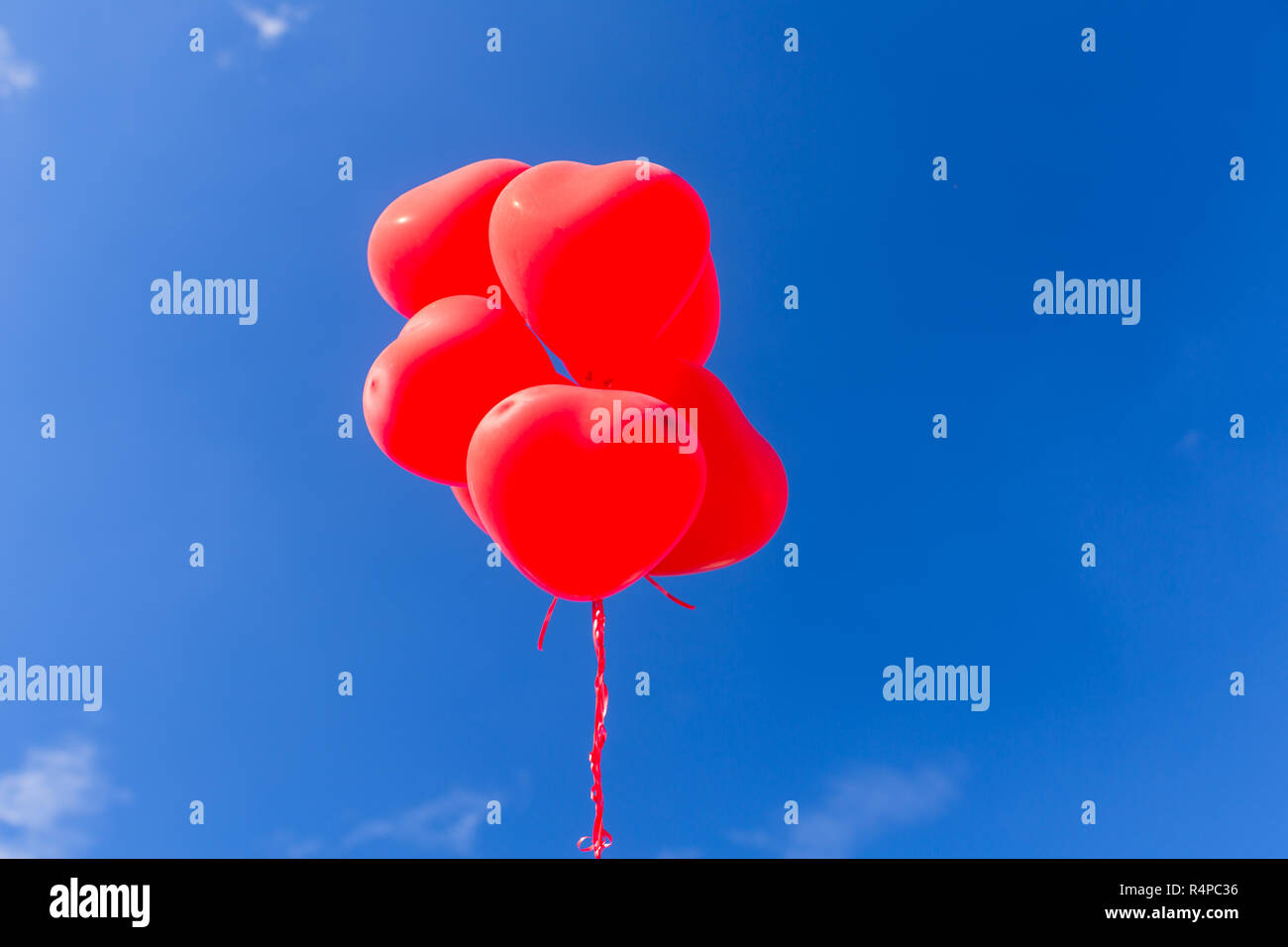 Red heart shaped helium balloons flying in the sky Stock Photo - Alamy