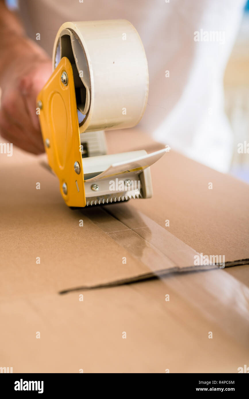 Man taping packing case Stock Photo - Alamy