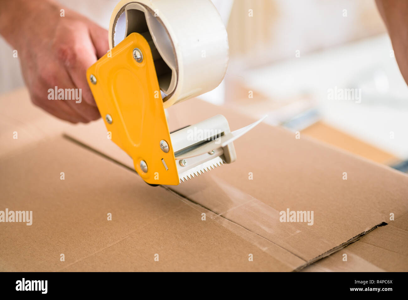 Man taping packing case Stock Photo - Alamy