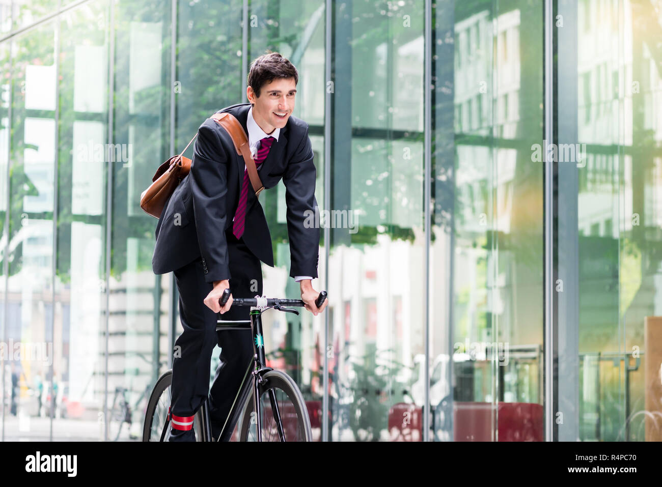 Cheerful young employee riding an utility bicycle in Berlin Stock Photo ...