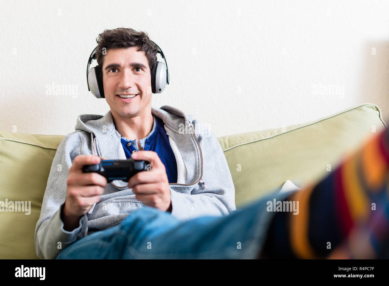 Happy young man playing a video game on console at home Stock Photo - Alamy