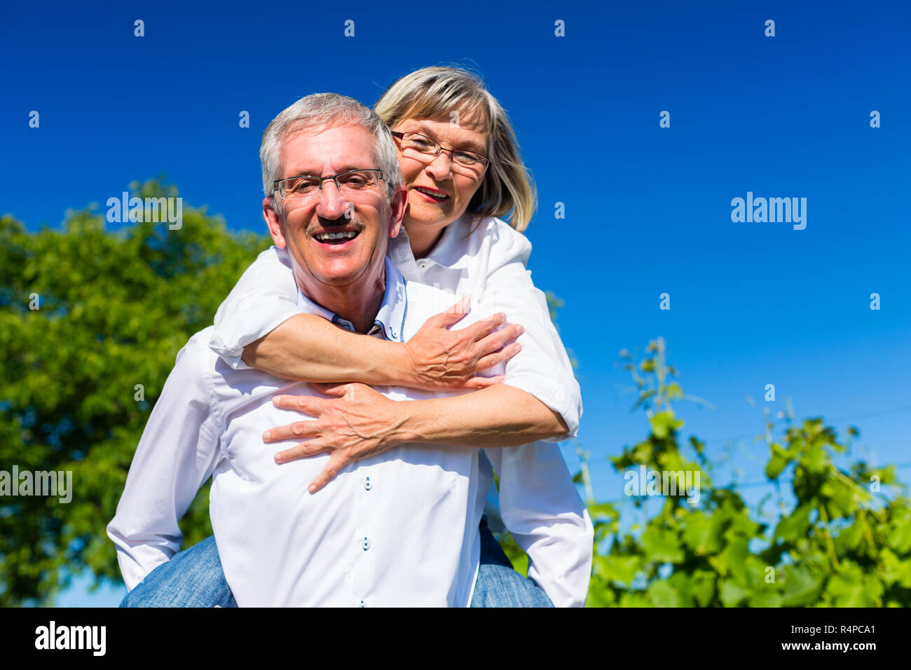 Senior woman hugging her man from behind Stock Photo - Alamy