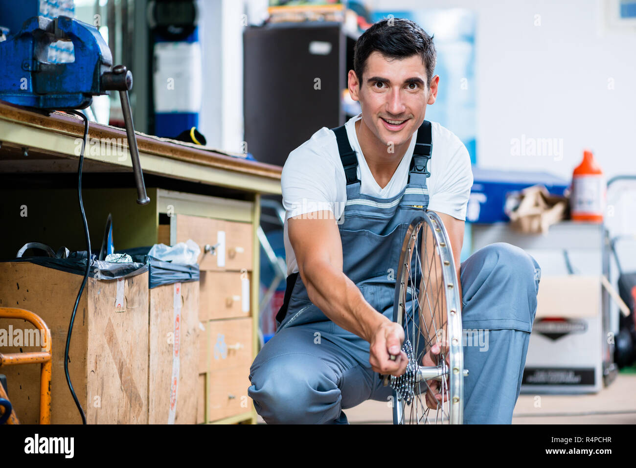 Man as bicycle mechanic working in workshop Stock Photo - Alamy