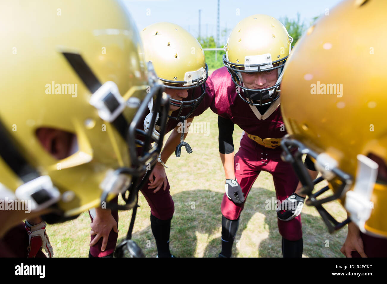 American Football players at strategy huddle Stock Photo - Alamy