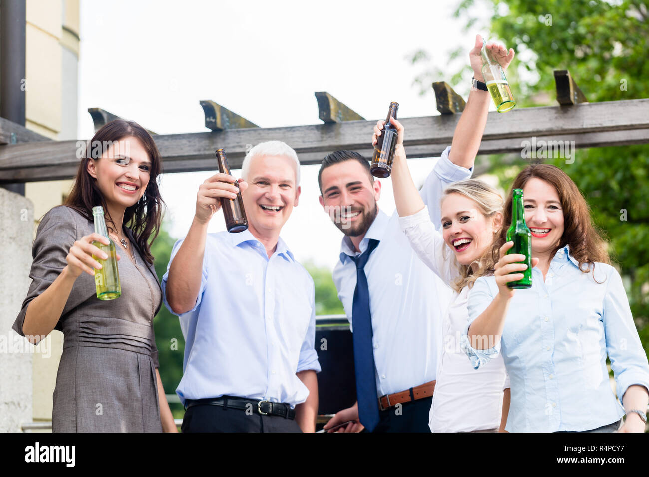 Office colleagues drinking beer after work Stock Photo - Alamy
