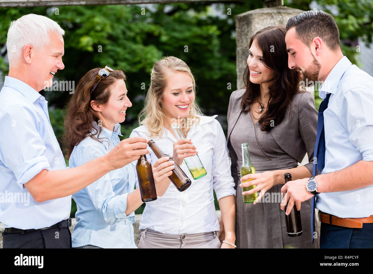 Office colleagues drinking beer after work Stock Photo - Alamy