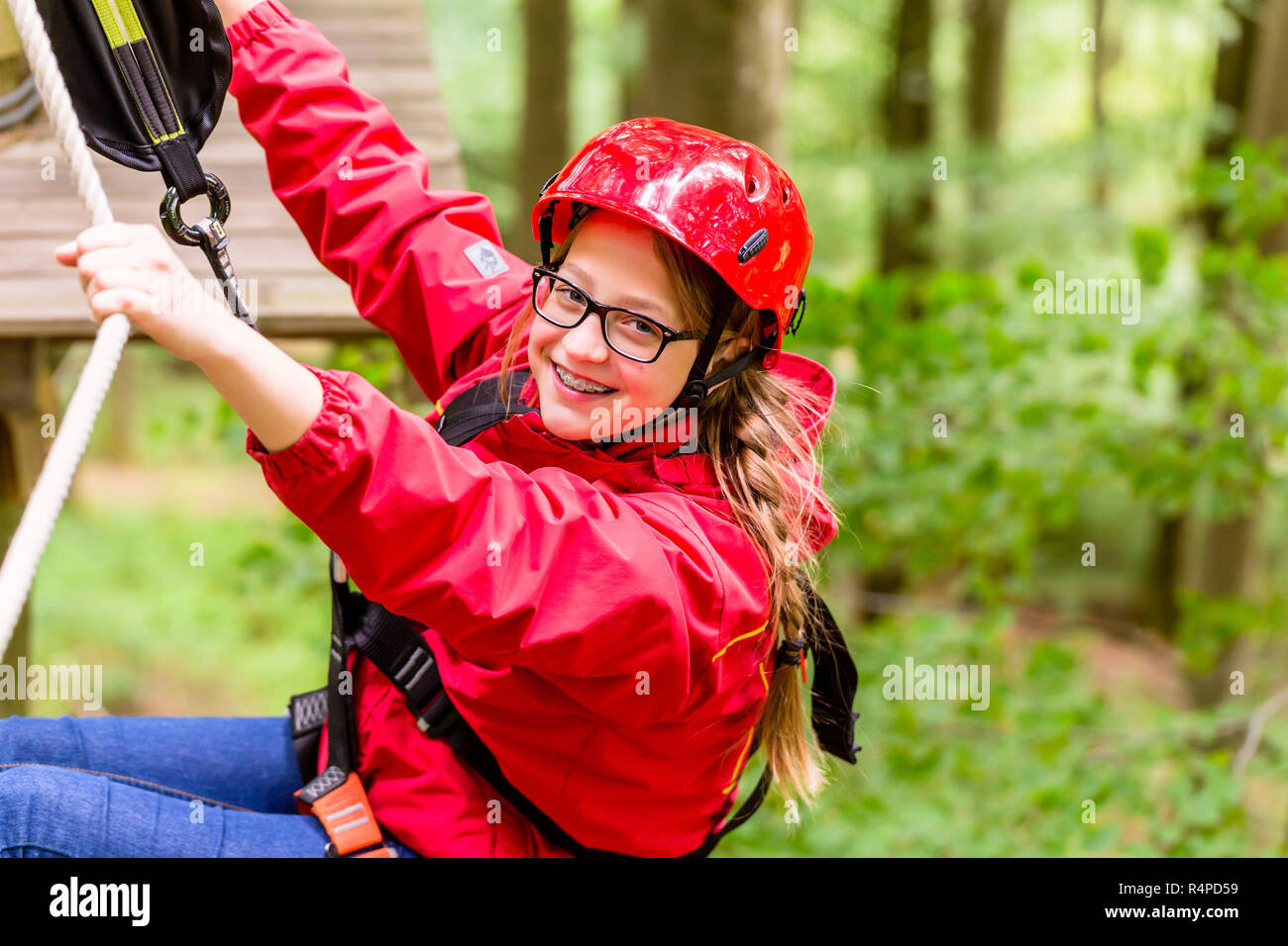 Child reaching platform climbing in high rope course Stock Photo - Alamy