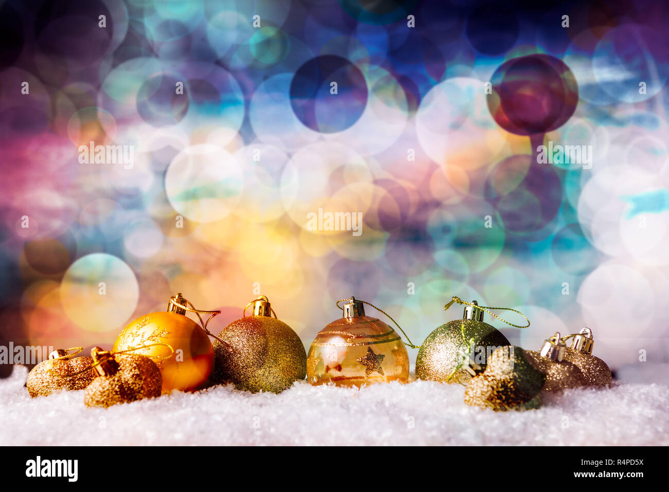Golden christmas ball on snow, against a beautiful holiday inspired ...