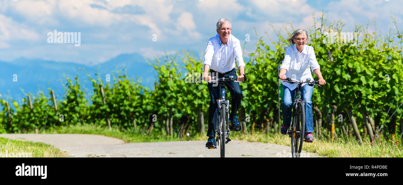 Seniors riding bicycle in vineyard together Stock Photo - Alamy