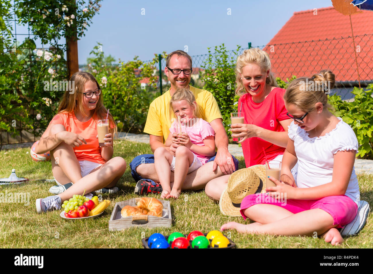 Family having picnic in garden front of their home Stock Photo - Alamy