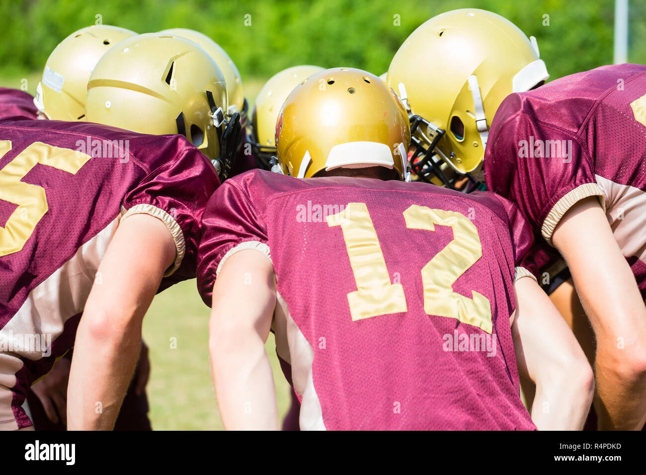 American Football players at strategy huddle Stock Photo - Alamy