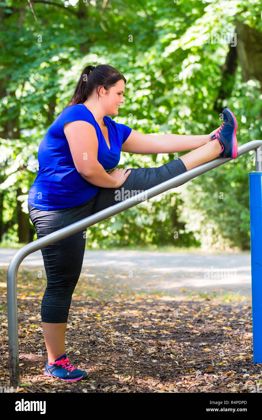 Obese woman doing sport stretching outdoors in park Stock Photo - Alamy