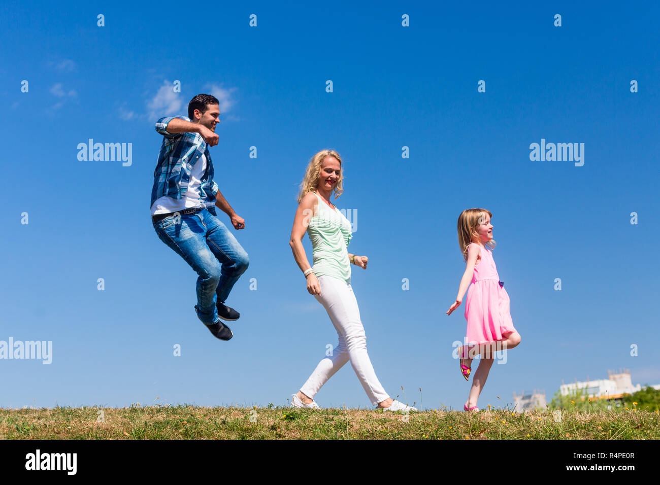 Mom and daughter walk in single file, on is jumping Stock Photo - Alamy