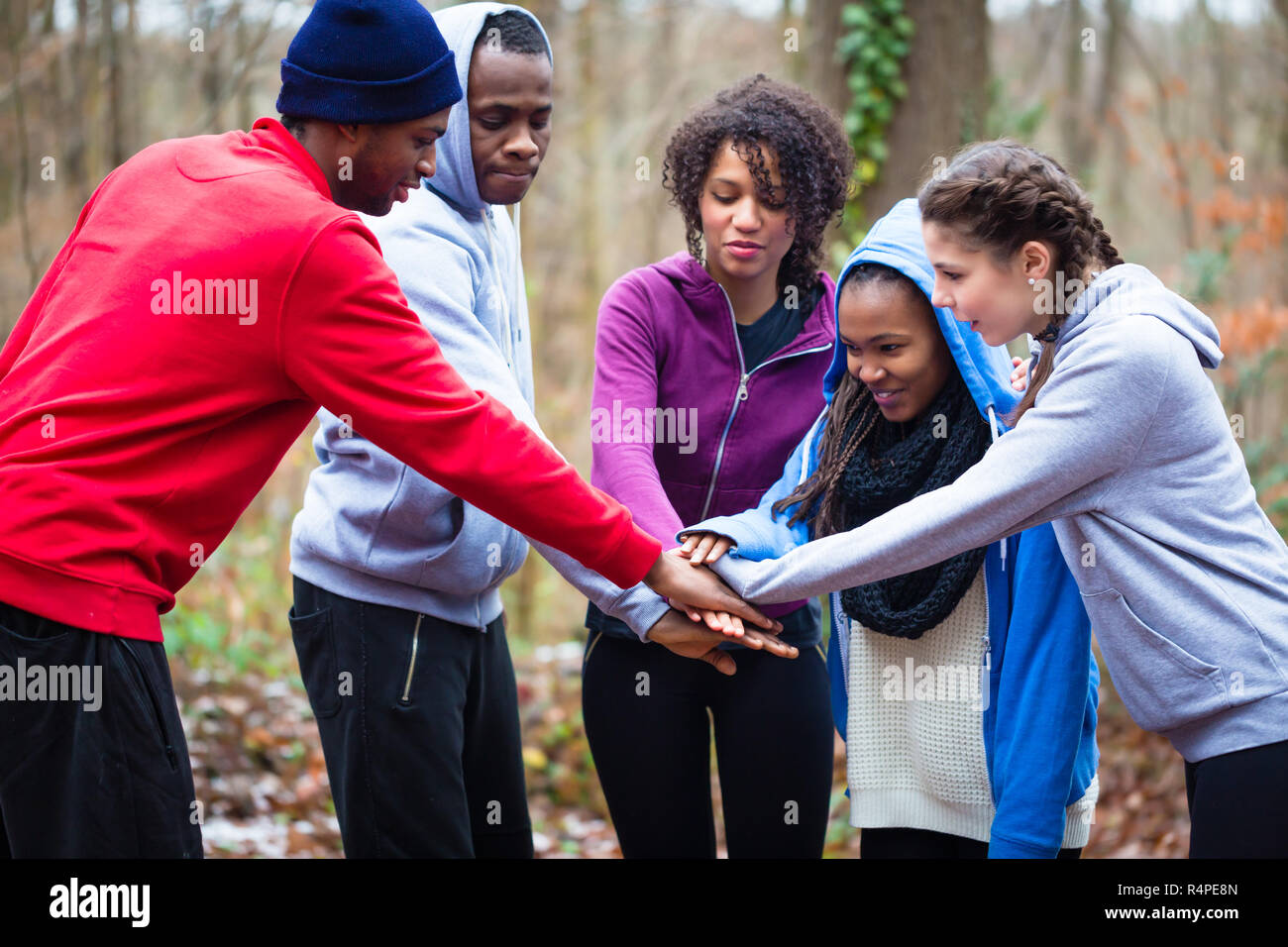 Five young people holding hands together before workout Stock Photo - Alamy