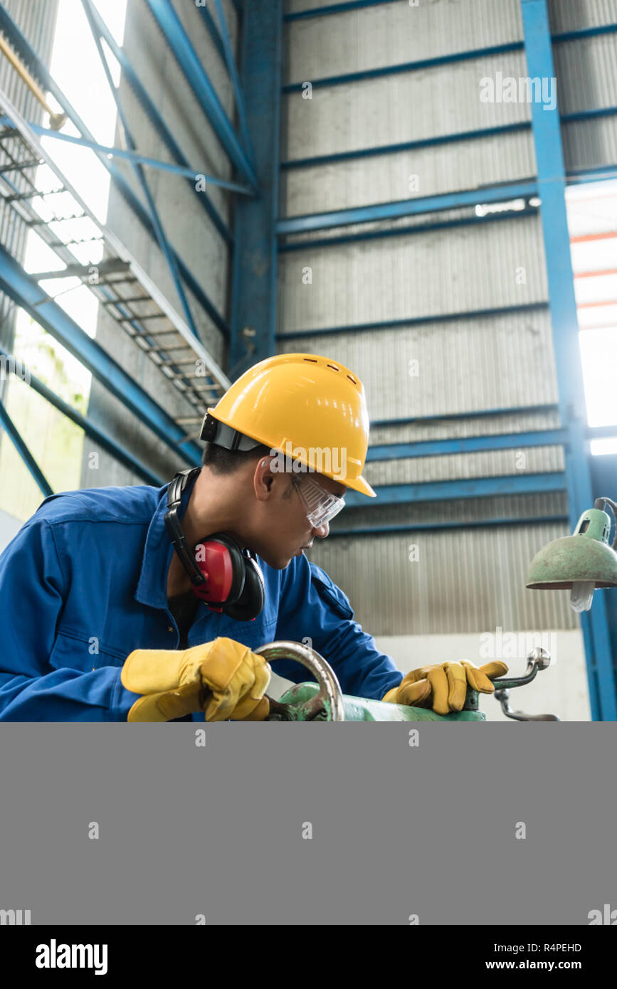 Worker checking quality behind an industrial machine Stock Photo - Alamy