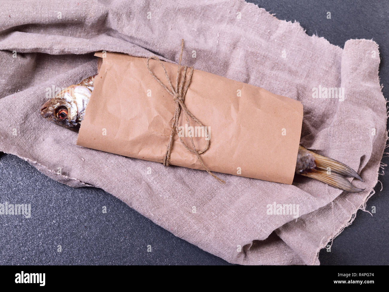 dried fish roach wrapped in brown craft paper Stock Photo - Alamy
