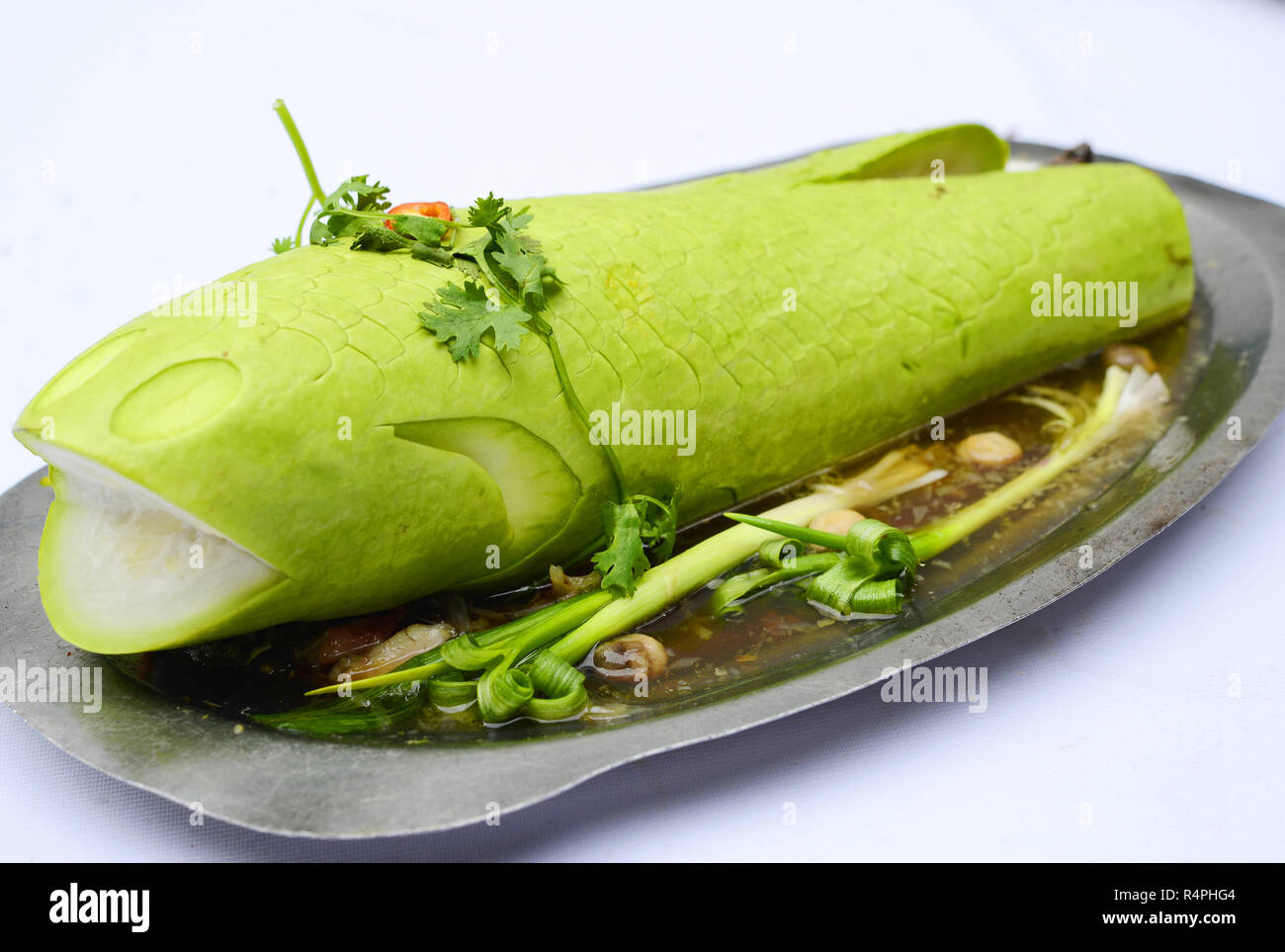 Snakehead fish steamed gourd with onion and herbs on white background ...