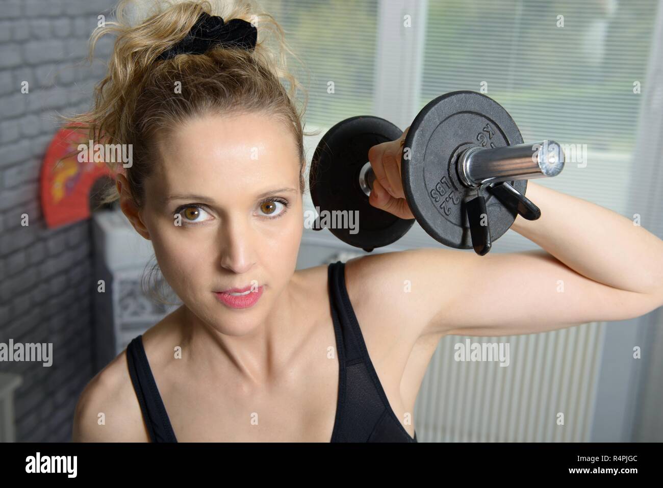 pretty fitness woman lifting dumbbells Stock Photo - Alamy