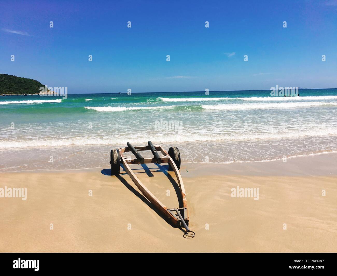 The wheelbarrow on the beach with sea wave foam Stock Photo - Alamy