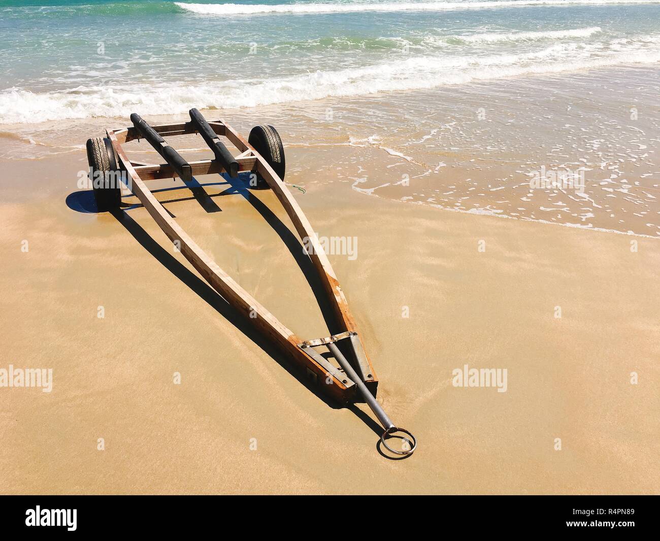 The wheelbarrow on the beach with sea wave foam Stock Photo - Alamy