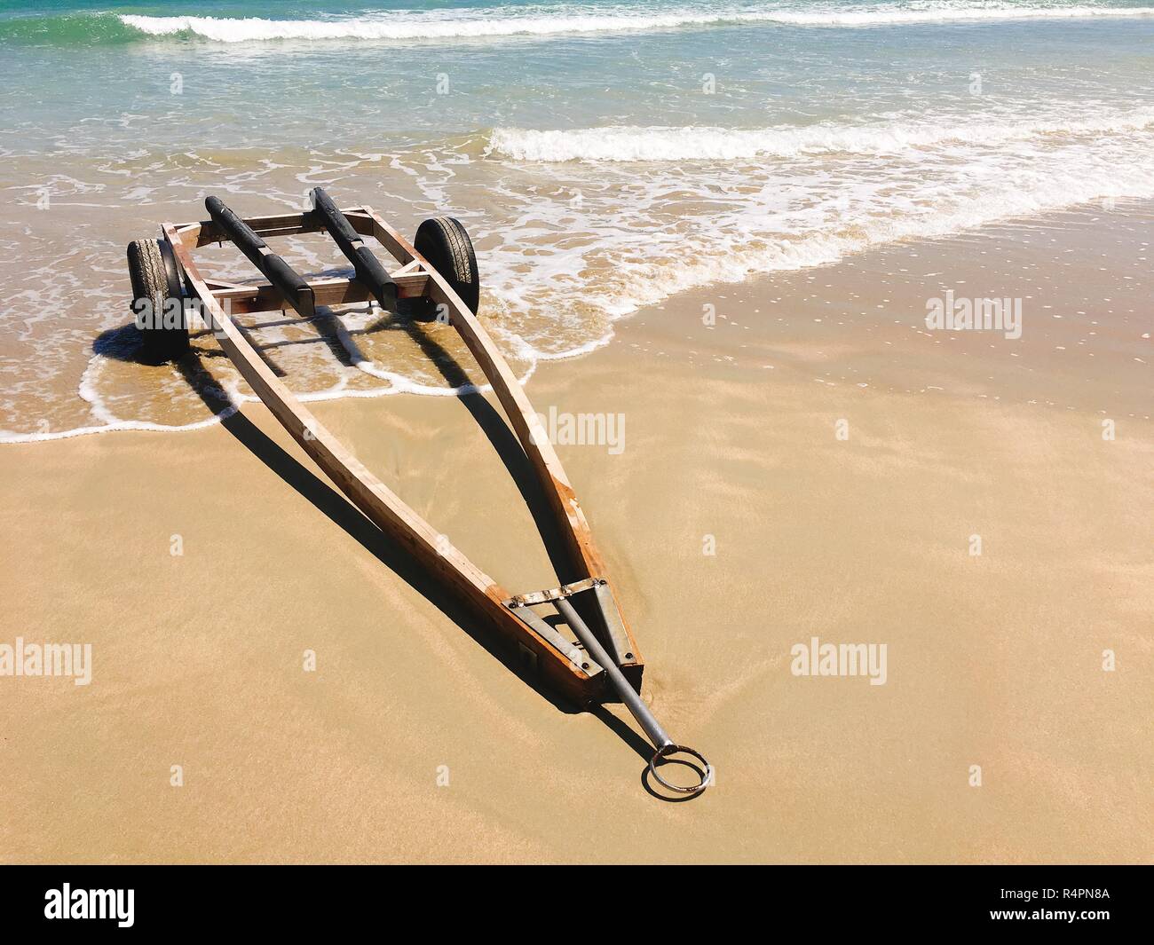 The wheelbarrow on the beach with sea wave foam Stock Photo - Alamy