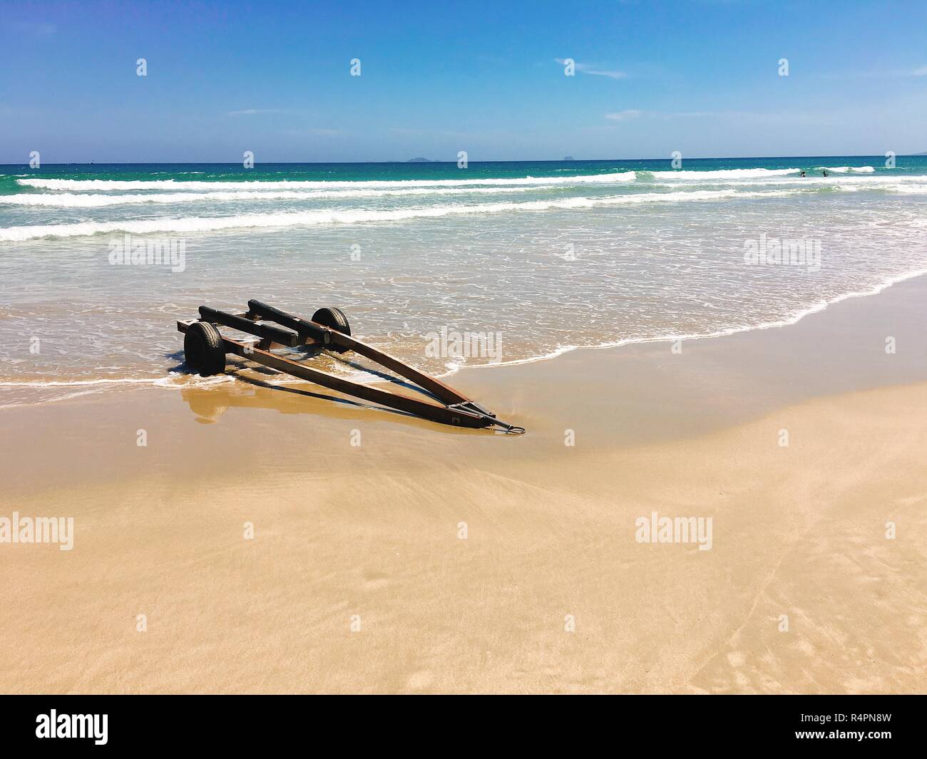 The wheelbarrow on the beach with sea wave foam Stock Photo - Alamy