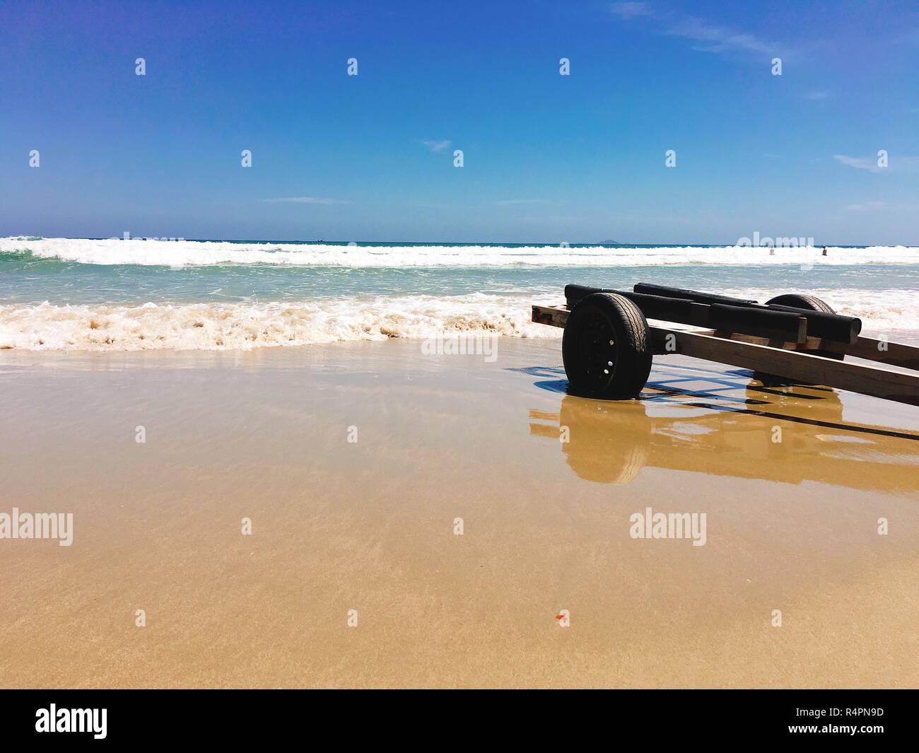 The wheelbarrow on the beach with sea wave foam Stock Photo - Alamy