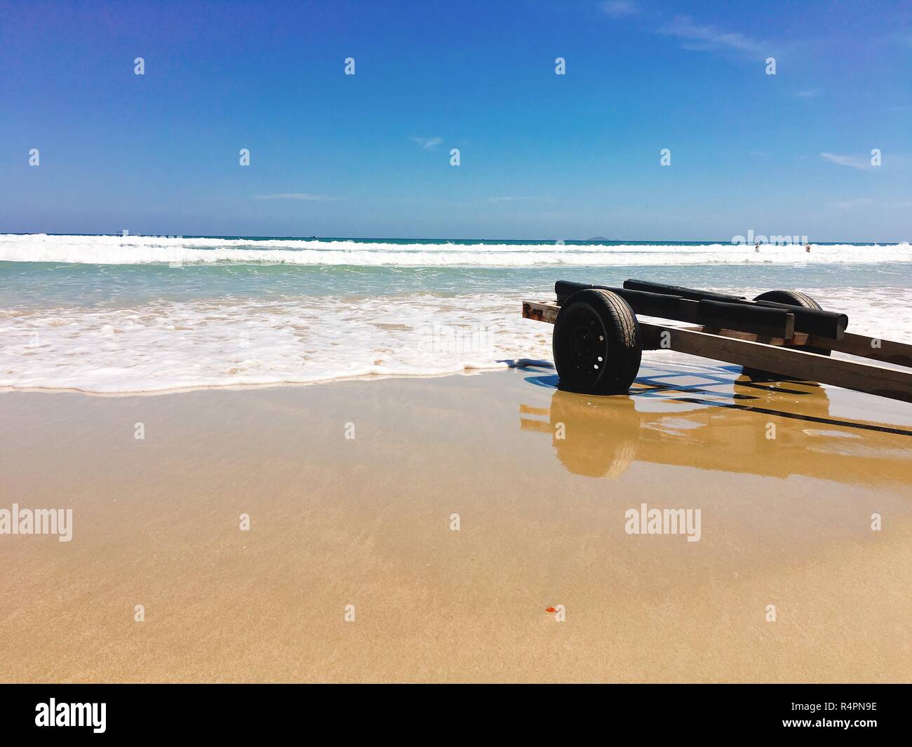 The wheelbarrow on the beach with sea wave foam Stock Photo - Alamy