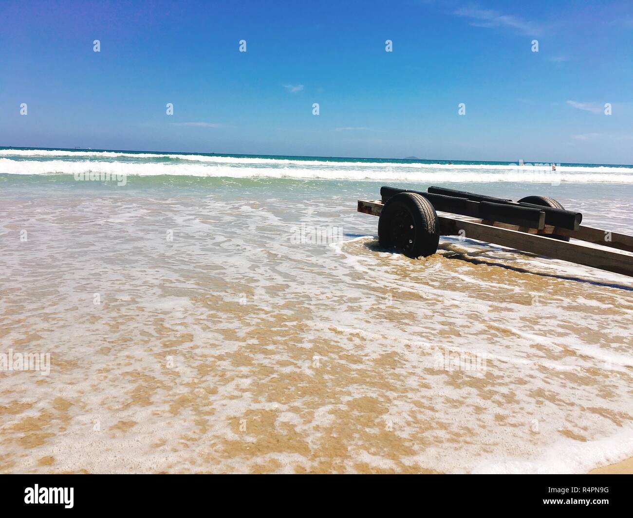 The wheelbarrow on the beach with sea wave foam Stock Photo - Alamy