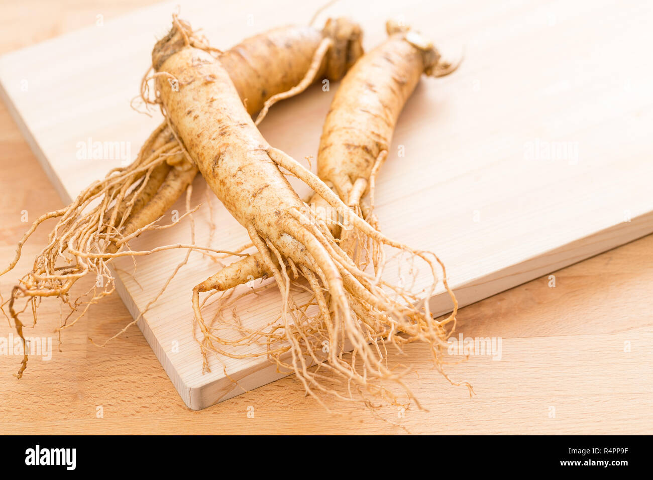 Fresh ginseng over wooden texture Stock Photo - Alamy
