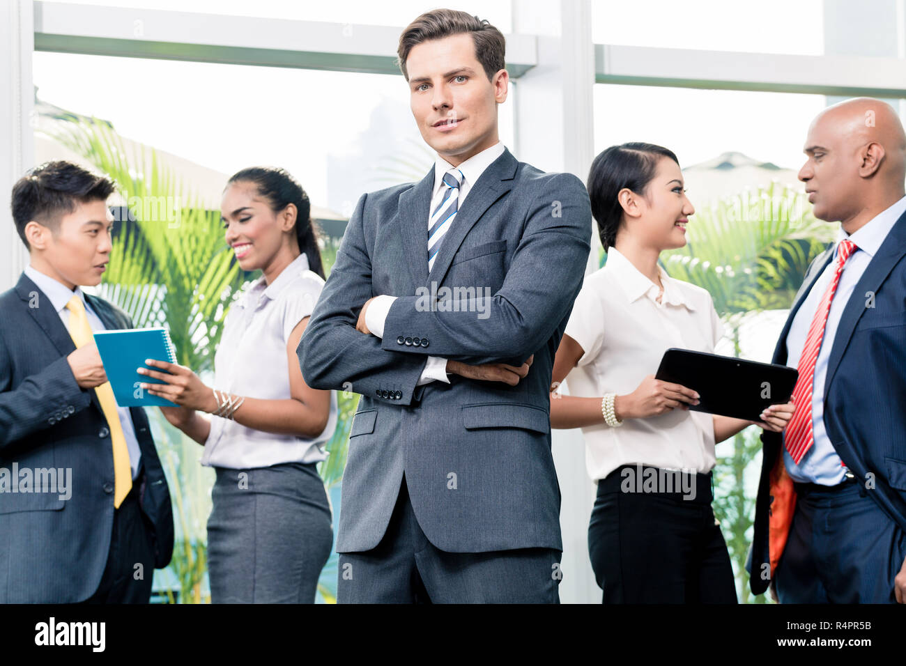 Business team meeting with man in front looking at camera Stock Photo ...