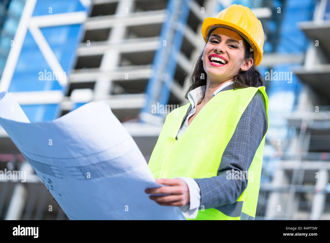 Female civil engineer studying drafts visiting construction site Stock ...