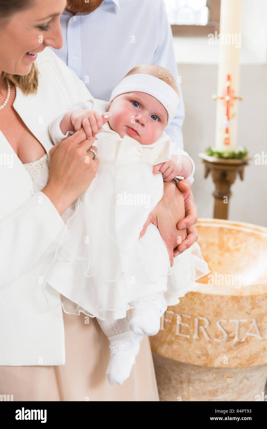 Parents with baby at christening in church Stock Photo - Alamy