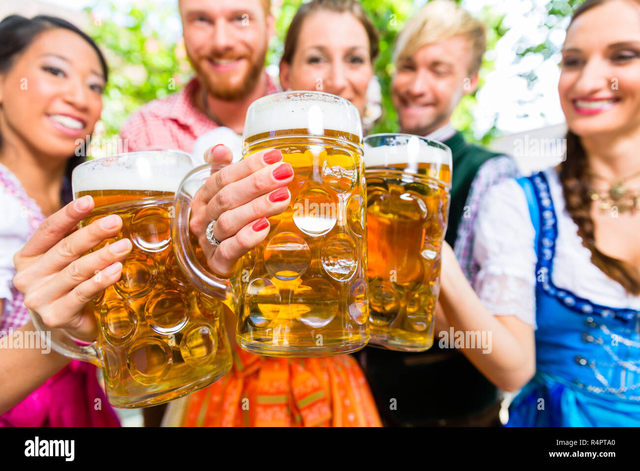 Friends in beer garden with beer glasses Stock Photo - Alamy